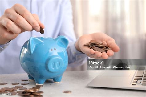 실내 테이블에 있는 돼지 저금통에 동전을 넣는 남자 근접 촬영 개념에 대한 스톡 사진 및 기타 이미지 개념 개념과 주제 경제 Istock