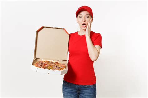 흰색 배경에 고립 된 빨간 유니폼에 배달 여자 꽤 여성 모자 티셔츠 청바지 택배 또는 골 판지 Flatbox에서 이탈리아 피자를 들고 딜러로 일하고 광고에 대 한 공간을