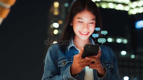 Hand Of Woman Typing Text On Mobile Smartphone In City Night Life Stock