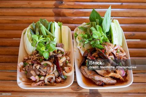 인기있는 태국 요리 나무 테이블 배경 위에 민트 잎과 라브 남 톡매운 슬라이스 돼지 고기 샐러드 조리법을 닫습니다 태국의 전통 음식 태국 북동부 음식 가루로 빻은에 대한