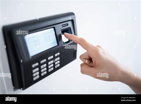 Closeup Woman Employee Using Biometric Fingerprint Attendance System Machine With Numeric Keypad