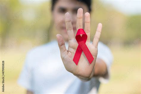 Hand Holding Red Ribbon For Supporting People Living And Illness Healthcare And Safe Sex