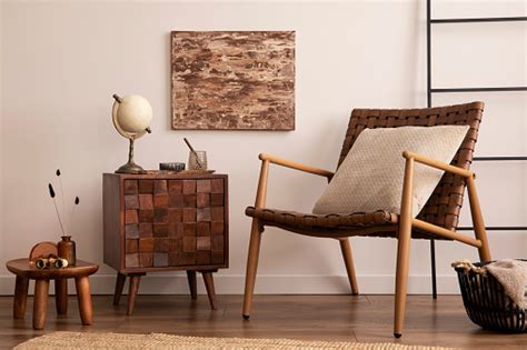 모형 포스터 프레임 나무 사이드 보드 세련된 안락 의자 베이지 색 베개 바구니 격자 무늬 및 개인 액세서리가있는 미학적이고 우아한 객실의 인테리어 디자인 가정 장식 템플렛