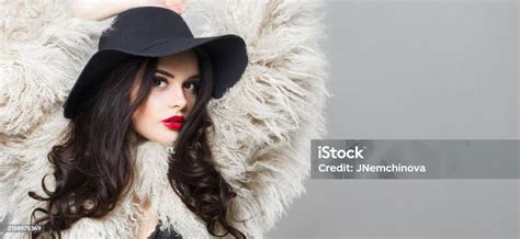 밝은 메이크업과 긴 웨이브 머리를 가진 춤추는 젊은 성인 여성 패션 모델 흰색 스튜디오 벽 배경에 대해 포즈를 취하는 파란색 모자를 착용 검은색에 대한 스톡 사진 및 기타