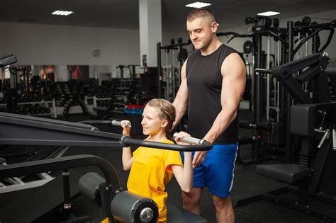 Premium Photo Girl Performs An Exercise On Simulator Coach Teaches