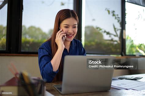 자연을 테마로 한 사무실에서 노트북과 책상 위에 서류를 놓고 전화로 일에 대해 이야기하는 사업가 25 29세에 대한 스톡 사진 및 기타 이미지 Istock