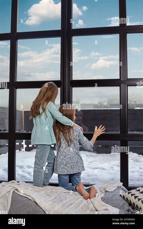 The Image Of Two Little Sisters Sitting On Windowsill Looking At The