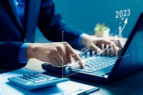 가상 홀로그램 차트 그래프로 책상 위에서 2023 년 비즈니스 성장을 계획하는 사업가 투자에 대한 소득과 이익 계산 및 긍정적