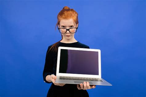 똑똑한 심각한 빨간 머리 십대 소녀 안경에 빈 화면 모의 와 노트북을 보유 파란색 배경에 페이지를 삽입 10 11세에 대한 스톡 사진 및 기타 이미지 Istock