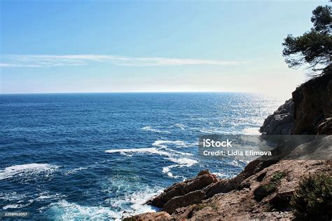 파도와 하늘이 있는 바위가 많은 해안선 해안 바위에 부딪히는 바다 파도 바위가 많은 해안선이 있는 바다 전망 바위와 푸른 지중해가 있는 풍경 스페인의 바위에 부서지는 파도