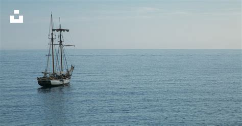 낮 동안 흰 구름 아래 바다에 검은 범선 사진 Unsplash의 무료 배 이미지