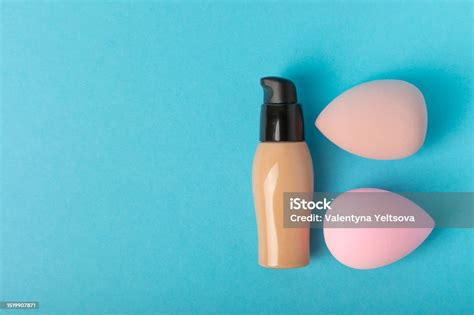 배경에 파운데이션과 파우더가 있는 뷰티 블렌더 메이크업 화장품을위한 밝은 스폰지 메이크업 제품 아름다움 개념입니다 텍스트를 위한 위치입니다 복사를 위한 공간입니다 플랫 레이