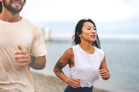 여름 운동복을 입고 모래사장에서 달리는 쾌활한 젊은 다민족 커플 2명에 대한 스톡 사진 및 기타 이미지 2명 건강한 생활