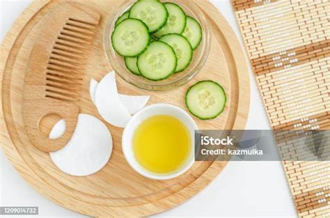 올리브 오일 오이 슬라이스 면 패드와 눈 패치와 나무 머리 빗 집에서 만든 얼굴과 헤어 마스크를 준비하기위한 성분 자연 미용 트리트먼트 레시피와 제로 폐기물 개념 상단 보기