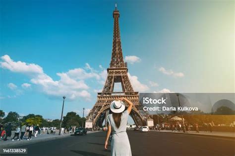 파리의 에펠탑 앞에 서 있는 태양 모자를 쓴 여성 관광객의 뒷모습 프랑스 여행 관광 개념 휴일 또는 파리 에서 휴가 파리 일 드 프랑스에 대한 스톡 사진 및 기타 이미지