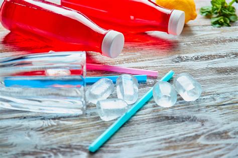 딸기와 페트 병 상쾌한 음료 흩어진 얼음 조각과 마시는 빨 대 초라한 나무 테이블의 배경에 닫습니다 복사 공간 0명에 대한 스톡 사진 및 기타 이미지 Istock