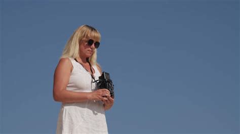 A Woman Presses The Button On The Camera And Takes A Picture GIF 23122772