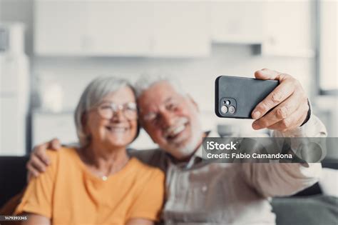 핸드폰으로 셀카를 찍는 행복한 노부부 웃고 있는 고위 성숙한 배우자 중년의 아내와 은퇴한 남편이 전화를 들고 웃고 있다 스마트폰 카메라에 자화상을 만들고 모바일 디스플레이에