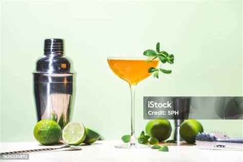 화이트 럼 라임 주스 스파클링 와인 시럽 비터 민트 얼음을 곁들인 오래된 쿠바 칵테일 음료 밝은 녹색 배경 하드 라이트 그림자