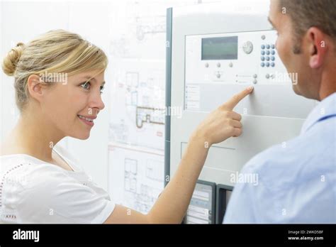 Woman Showing Electronic Control Machine To Colleague Stock Photo Alamy