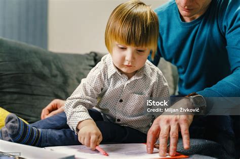 아버지와 함께 소파 침대에 앉아 있는 작은 백인 소년 아들과 아버지는 함께 집에서 배우고 그림을 그리는 데 시간을 보내고 있습니다 가족 시간 부모와 어린 시절 개념 2 3