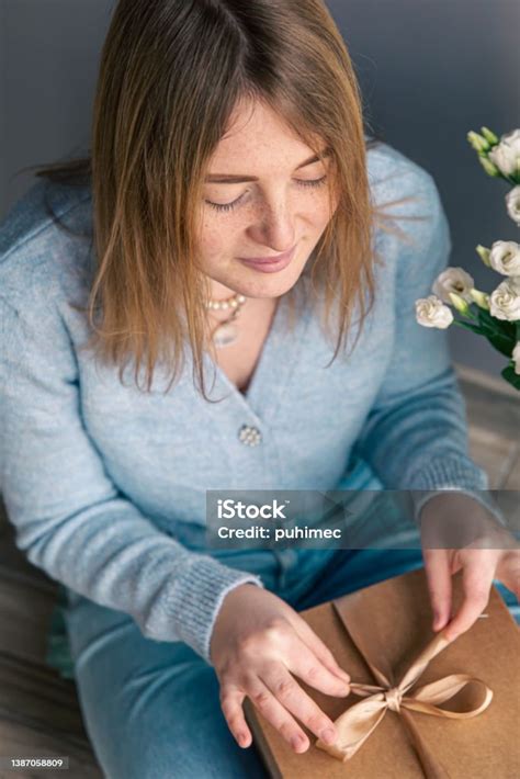 장미 꽃다발을 가진 한 젊은 여성이 선물 상자를 풀고 있다 20 24세에 대한 스톡 사진 및 기타 이미지 20 24세 공예 공휴일 Istock
