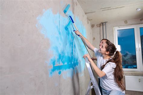 수리 작업 중 새 집에서 부부가 함께 벽을 칠합니다 새 집에서 파란색 페인트로 페인트 롤러 페인트 벽을 들고 있는 행복한 가족 주택 개조 Diy 갱신 주택 개념 20 24