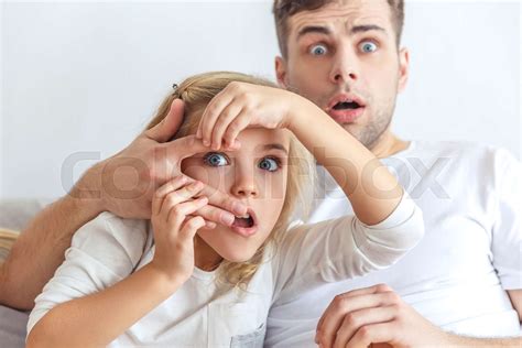 Shocked Father And Daughter Watching Scarry Movie Together Stock