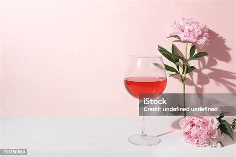로제 와인 알코올 칵테일 모란 꽃이 있는 현대적인 정물화 길고 단단한 그림자가 있는 파스텔 배경 바 카페 광고 배너에 대한 최소한의 개념 와인잔에 대한 스톡 사진 및 기타