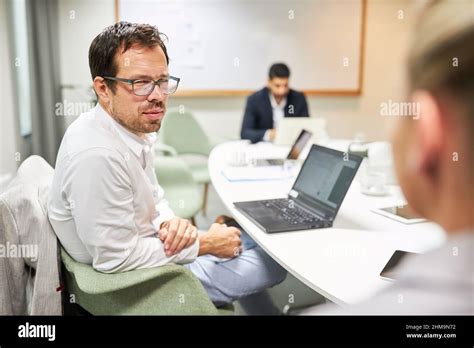Business Man As A Programmer Or Software Developer Sits At The Laptop Computer In The Office