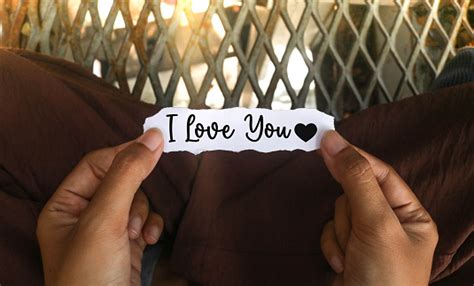 사랑한다는 메시지와 하트 이모티콘이 있는 찢어진 종이를 들고 있는 손의 평면도 낭만적 인 개념에 대한 애정과 감정을 표현하는 종이에 단어 깨짐에 대한 스톡 사진 및 기타