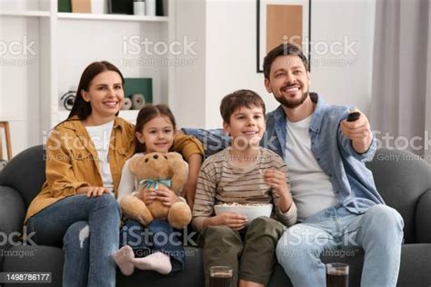 집에서 Tv를 보는 행복한 가족 아버지는 리모콘으로 채널을 변경합니다 가족에 대한 스톡 사진 및 기타 이미지 가족 텔레비전