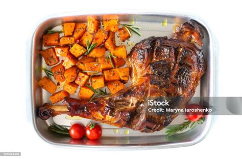 구운 칠면조 다리 호박 슬라이스에 향신료가 있는 용기에 흰색 배경에 고립 되어 있습니다 추수 감사절 고기 접시 맨 위 보기입니다