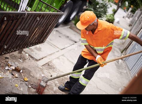 Ridding The Streets Of Rubbish Cropped Shot Of A Garbage Collection Worker Sweeping The