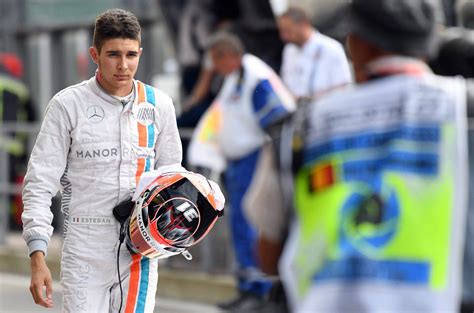 Download Esteban Ocon Holding His Racing Helmet During A Racing Event
