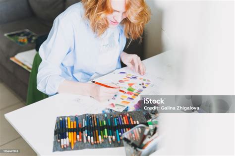 빨간 머리 일러스트레이터 예술가와 젊은 여자 는 홈 오피스에서 책상에 그립니다 가정 생활에 대한 스톡 사진 및 기타 이미지