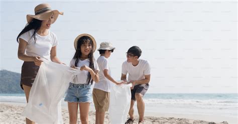 환경을 보호하기 위해 바다가 있는 해변에서 플라스틱 병을 줍는 아시아 가족 자원 봉사자 사진 Unsplash의 공생 이미지