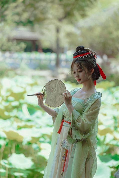 전통 의상을 입은 여자가 음식 한 그릇을 들고 있다 사진 Unsplash의 무료 의류 이미지