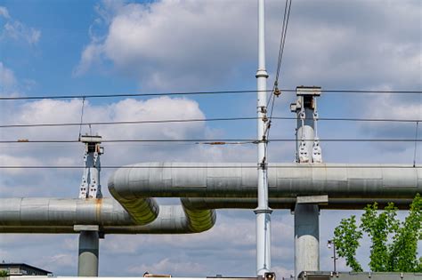 도시 지역을 가로지르는 지지대의 머리 위 지역 난방 파이프 배경에 견인 기둥과 전선이 있습니다 0명에 대한 스톡 사진 및 기타 이미지 Istock