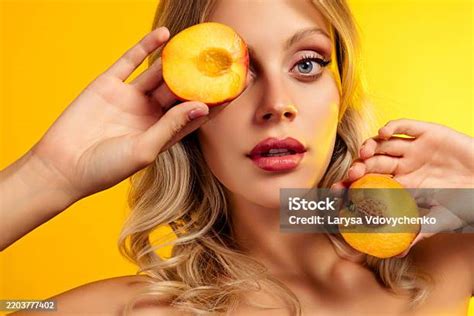노란색 파스텔 색상 배경에 고립 된 눈 반 복숭아 과일을 덮고있는 사랑스러운 예쁜 소녀 모델의 사진 20 24세에 대한 스톡 사진 및 기타 이미지 Istock