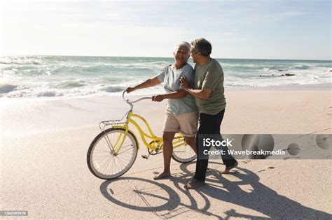 화창한 날에 해변에서 자전거를 타고 이야기하는 행복한 선임 다인종 커플 노인 커플에 대한 스톡 사진 및 기타 이미지 노인 커플 자전거 타기 2명 Istock
