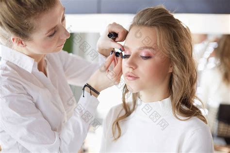 年轻美丽的新娘申请专业化妆师的婚纱化妆图片 包图网企业站