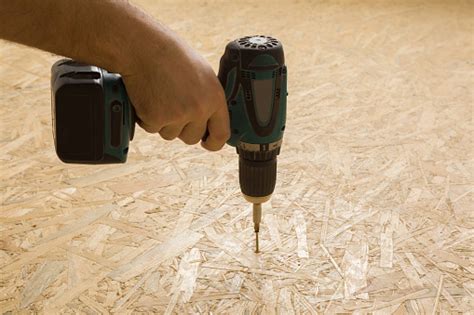 젊은 성인 남자 손 배터리 드라이버를 사용 하 여 바닥에 대 한 Osb 보드에 나사 나사 근접 촬영 측면 보기입니다 가정의 수리 작업 Diy에 대한 스톡 사진 및 기타