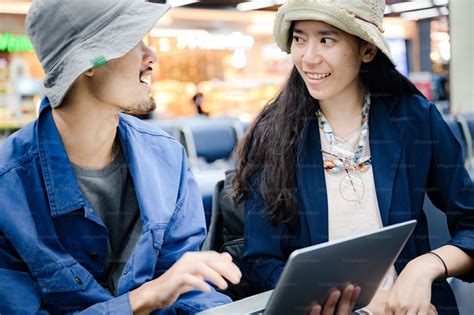 사업가는 앉아서 노트북 컴퓨터를 사용하여 공항에서 일하고 젊은 사람은 여행 여행을 떠나고 공항 출발시 실내에서 기다릴 때 인터넷 통신 기술을 가지고 있습니다 사진