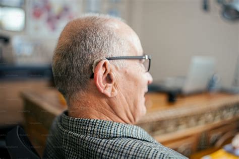 책상에 앉아 안경을 쓴 남자 사진 Unsplash의 보청기 이미지