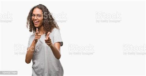 아름 다운 젊은 히스패닉 여자 행복 하 고 재미 있는 얼굴로 카메라를 손가락을 가리키는 안경을 착용 좋은 에너지와 느낌입니다 T 셔츠에 대한 스톡 사진 및 기타 이미지