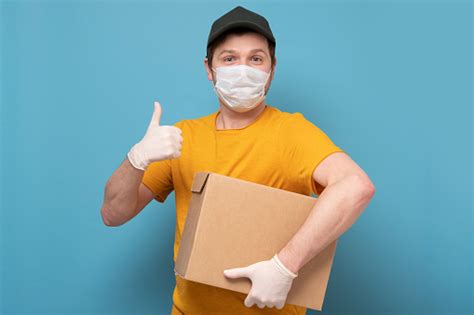 의료 용 고무 장갑과 엄지 손가락 최대 제스처를 보여주는 마스크에 골판지 상자를 들고 배달 남자 격리에 대한 스톡 사진 및 기타 이미지 Istock
