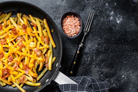 팬에 체다 치즈와 베이컨을 곁들인 황금 감자 튀김 검은 색 배경 맨 위 보기입니다 복사 공간 감자 요리에 대한 스톡 사진 및 기타 이미지 Istock