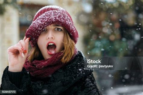 눈이 내리는 동안 거리에서 포즈를 취하는 빨간 모자를 쓰고 있는 예쁜 감정적인 여성 텍스트 공간 감기와 독감에 대한 스톡 사진 및 기타 이미지 Istock