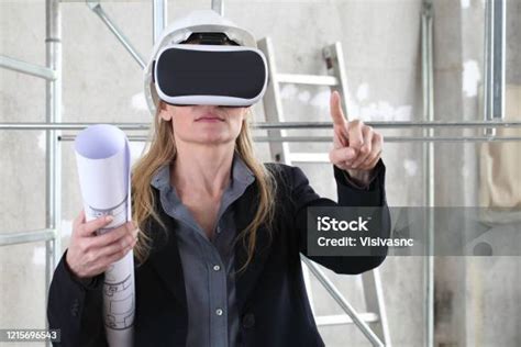 여성 건축가 또는 건설 엔지니어는 사다리와 비계가 있는 건물 부지 내부에 가상 현실 안경과 헬멧 터치 스크린을 착용합니다 가상현실에 대한 스톡 사진 및 기타 이미지 Istock